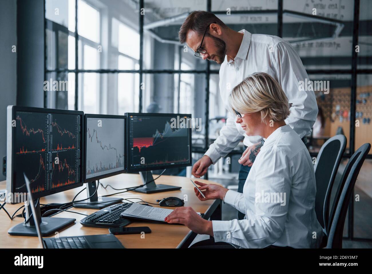 Analyzing information together. Two stockbrokers in formal clothes ...
