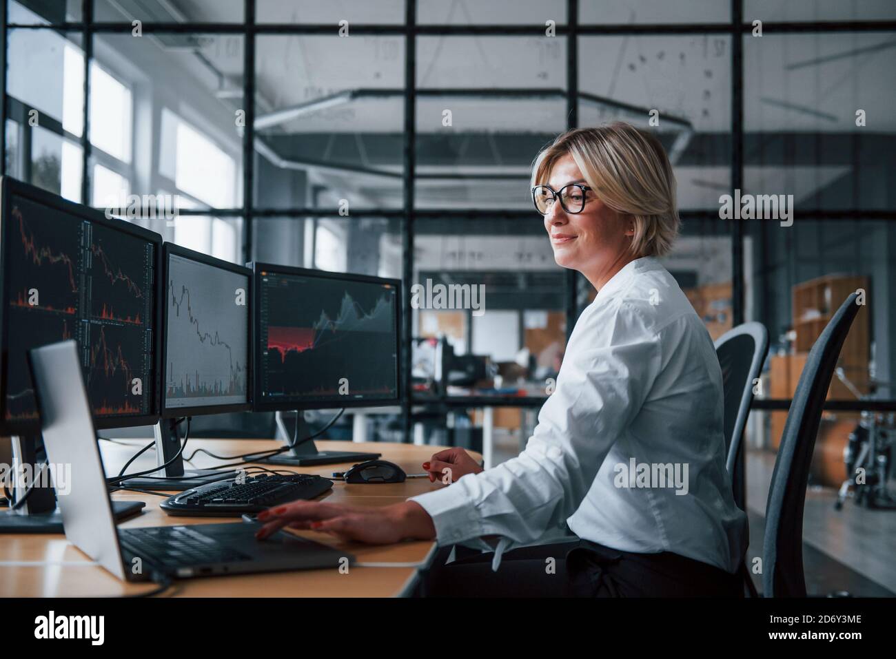 Female stockbroker in formal clothes works in the office with financial ...