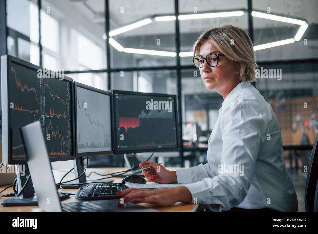 Female stockbroker in formal clothes works in the office with financial ...