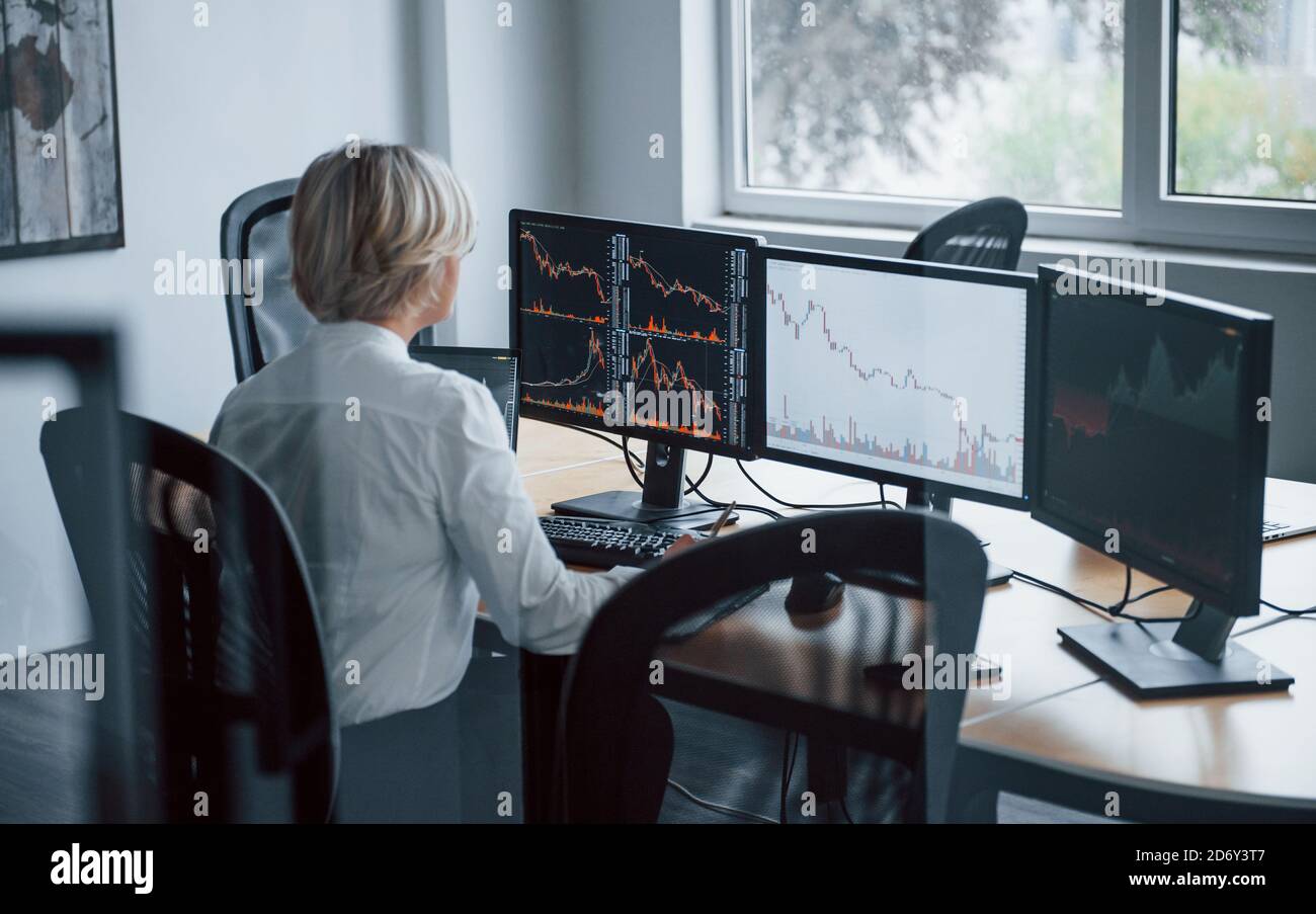 Female stockbroker in formal clothes works in the office with financial ...