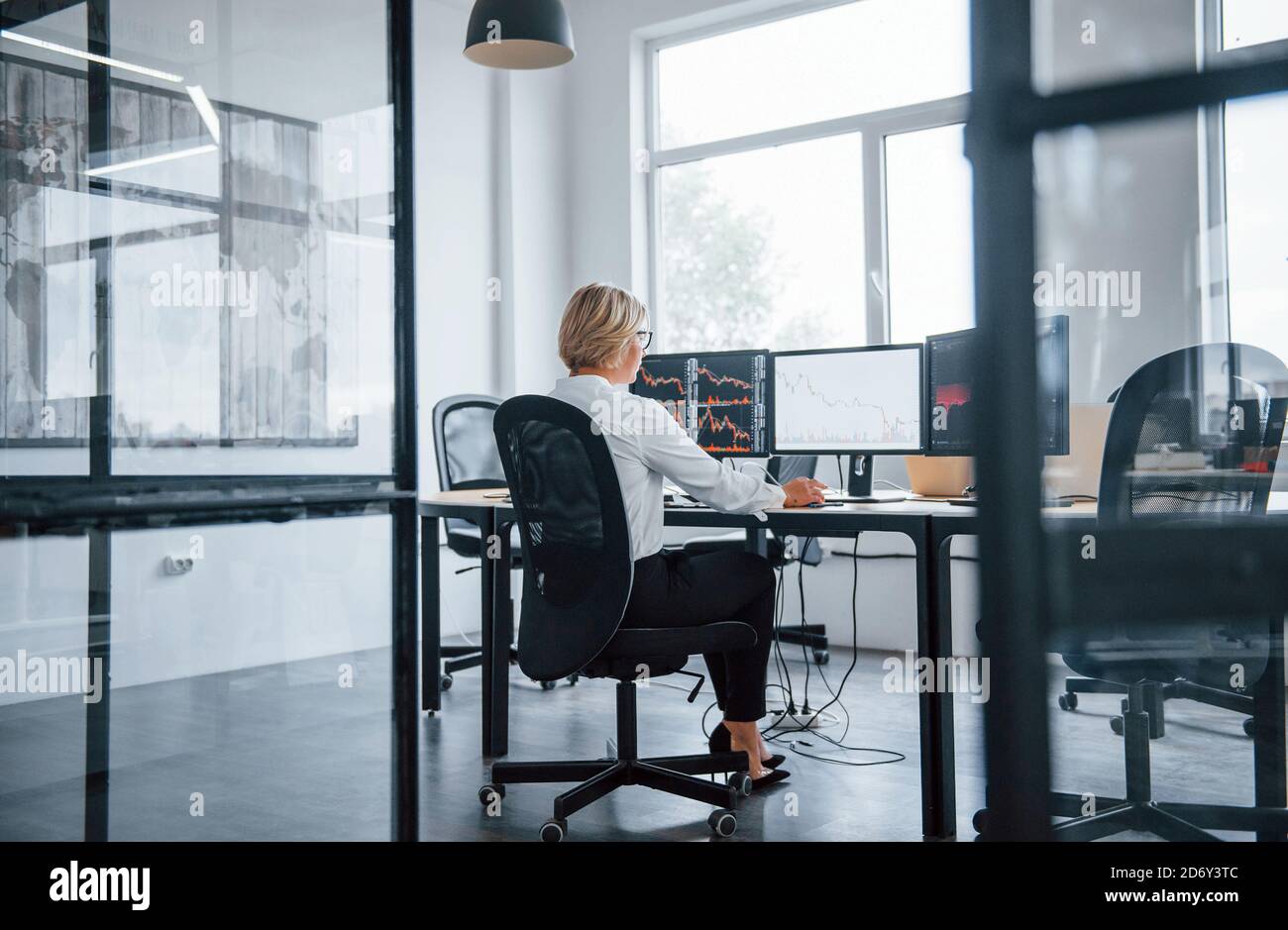 Female stockbroker in formal clothes works in the office with financial ...