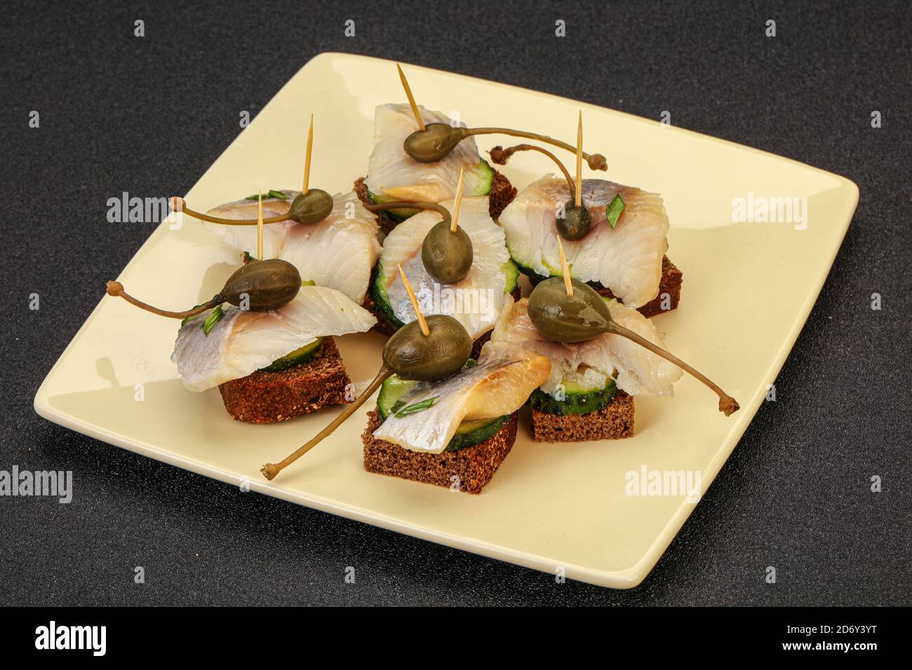 Herring fillet canape snack with caperberry and cucumber Stock Photo ...