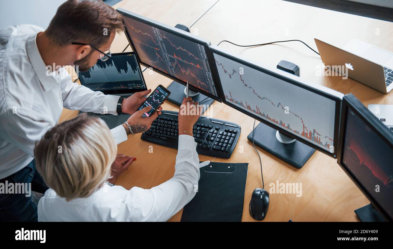 Top view. Two stockbrokers in formal clothes works in the office with ...