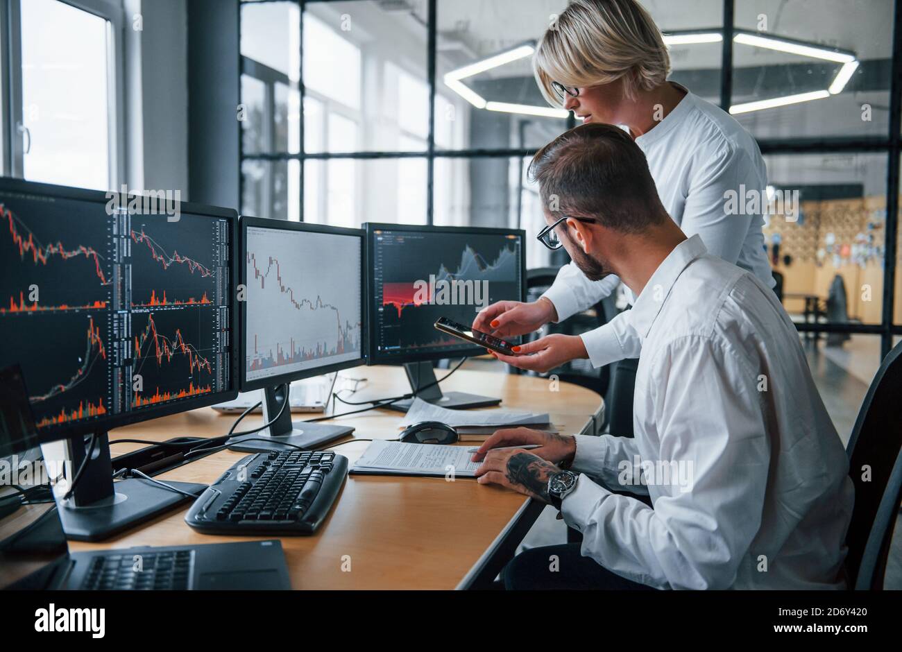 Analyzing information together. Two stockbrokers in formal clothes ...