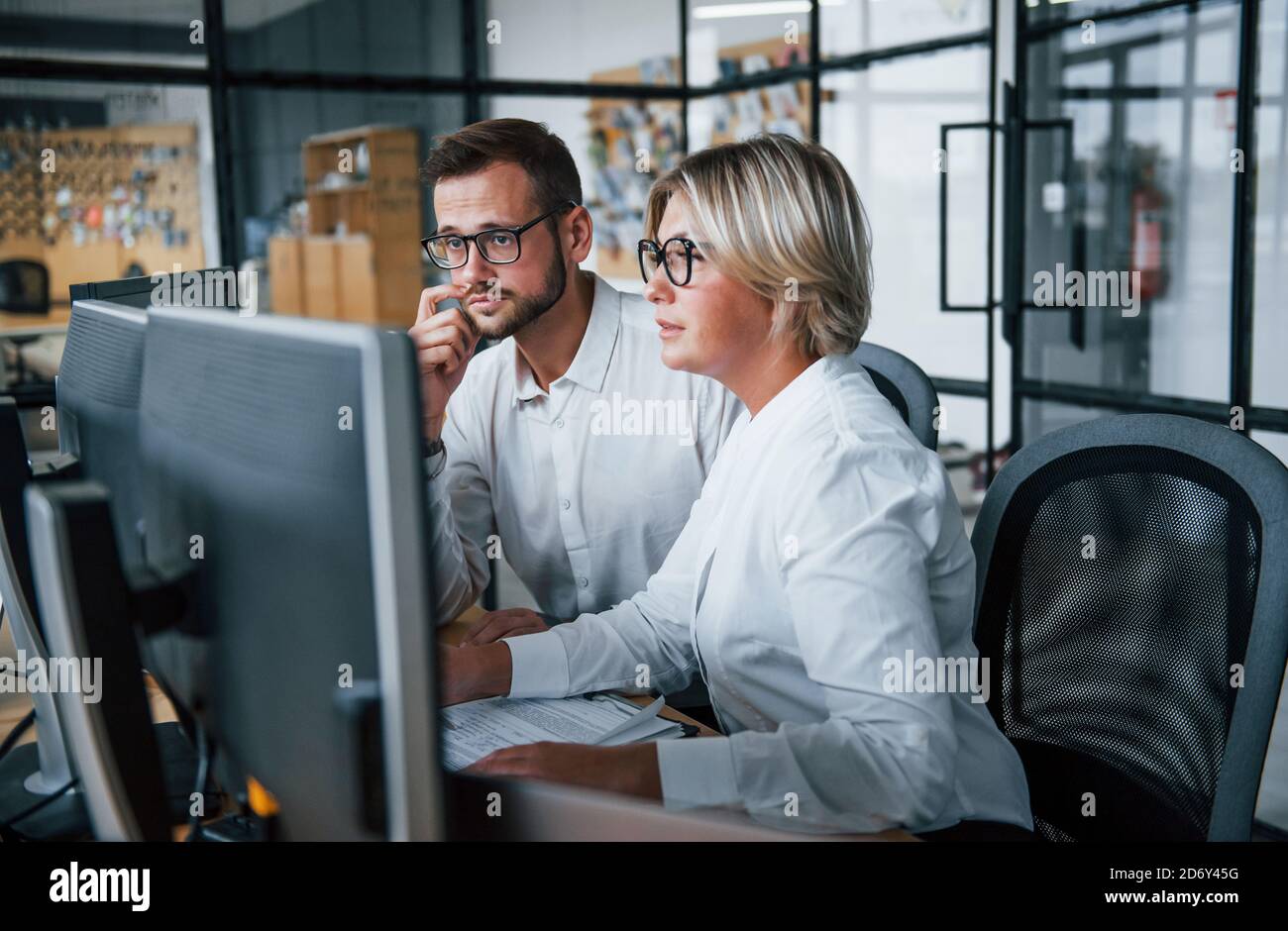 Two stockbrokers in formal clothes works in the office with financial ...
