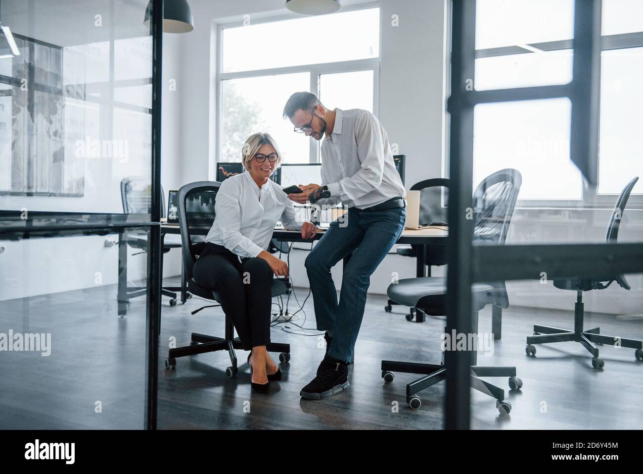 Two stockbrokers in formal clothes works in the office with financial ...
