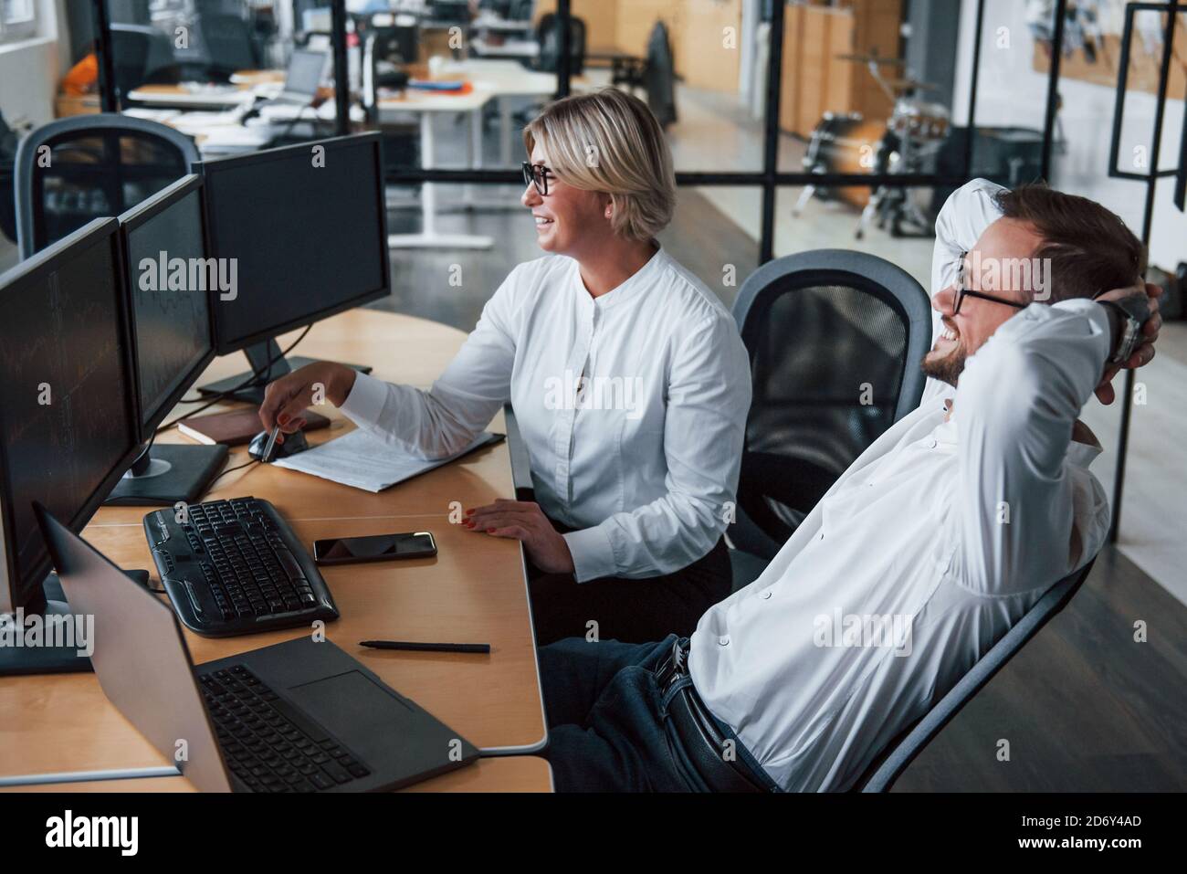 Two stockbrokers in formal clothes works in the office with financial ...