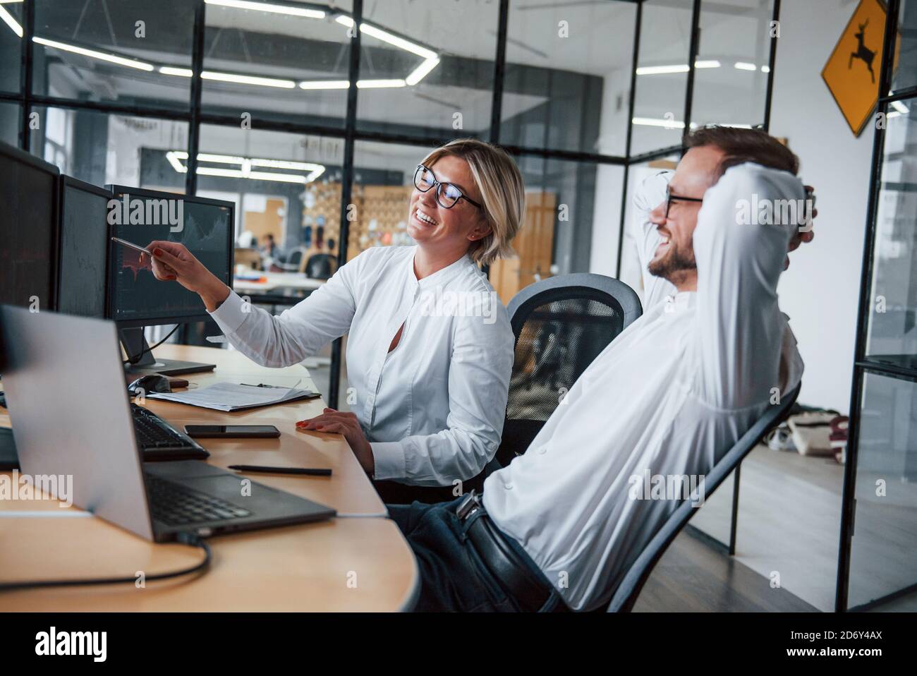 Two stockbrokers in formal clothes works in the office with financial ...