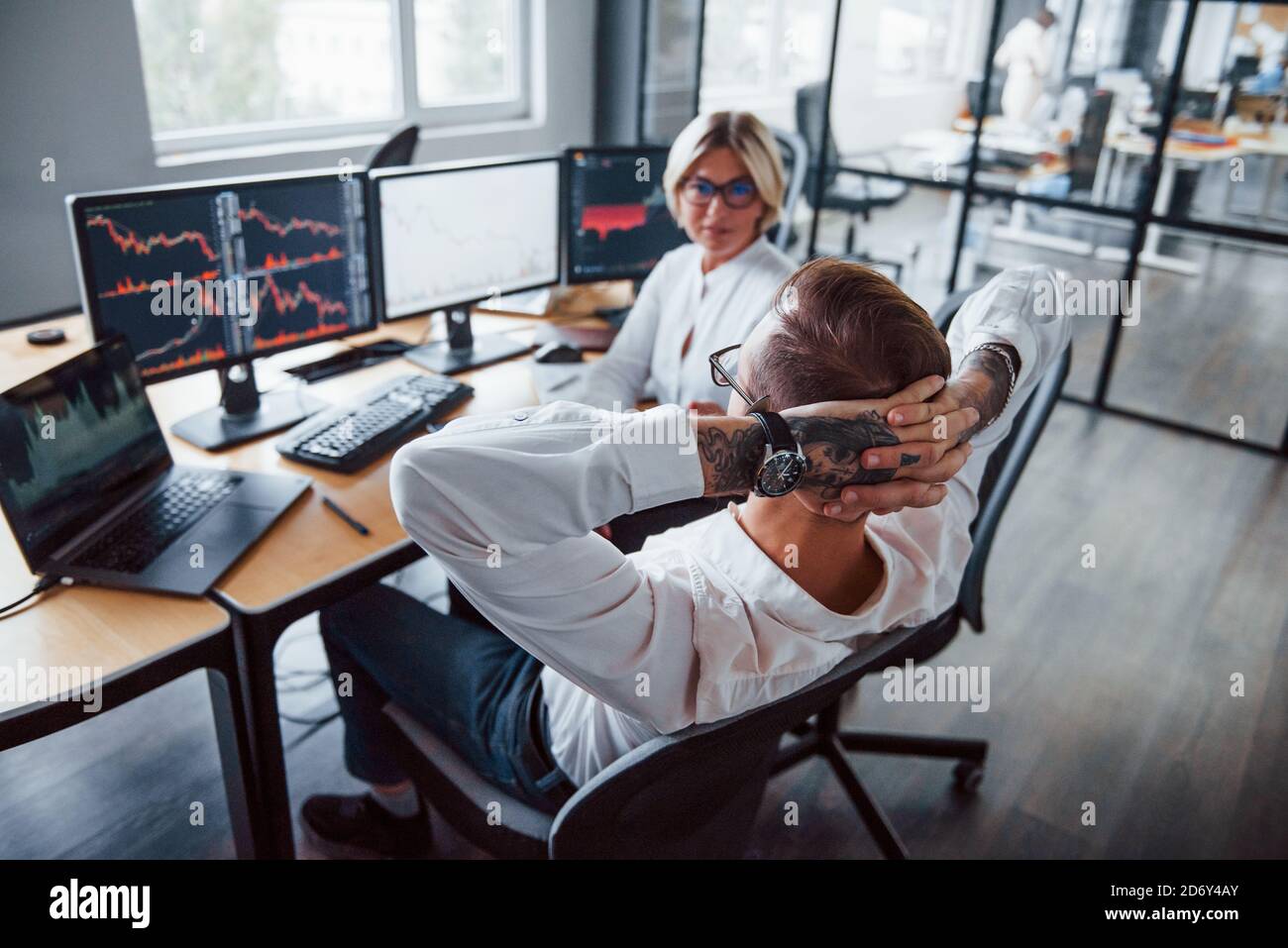 Talking to each other. Two stockbrokers in formal clothes have a break ...