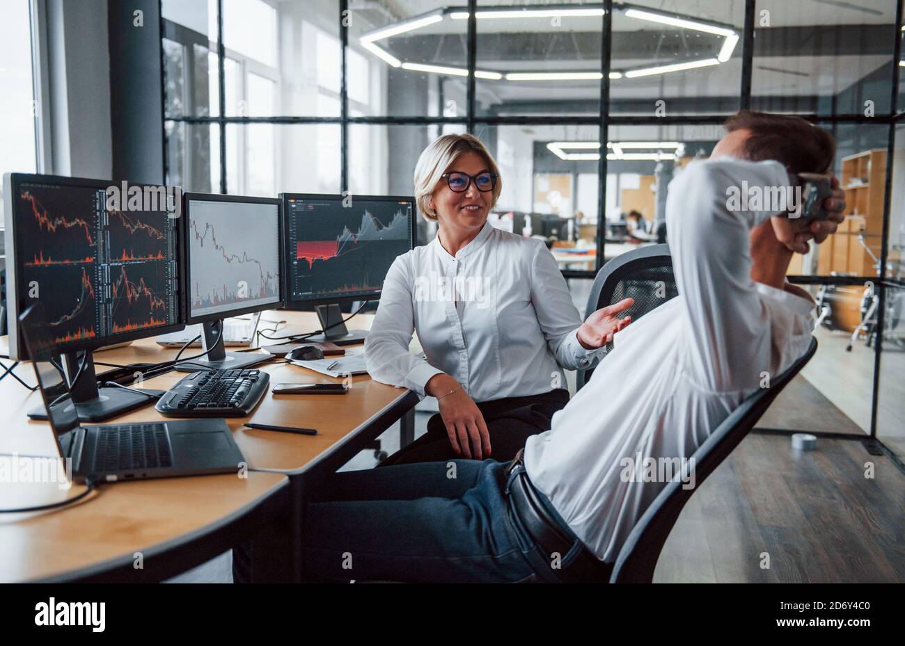 Talking to each other. Two stockbrokers in formal clothes have a break ...