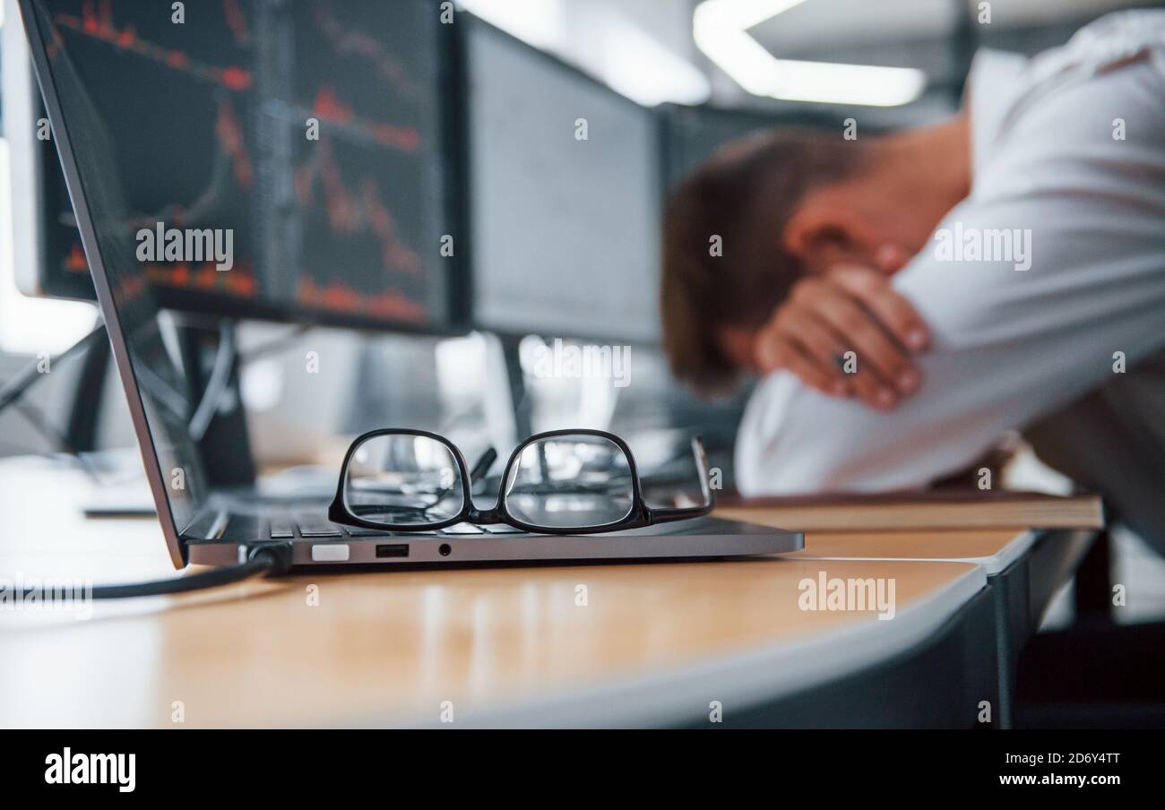 Tired businessman sleeping on the workplace by leaning on the table ...