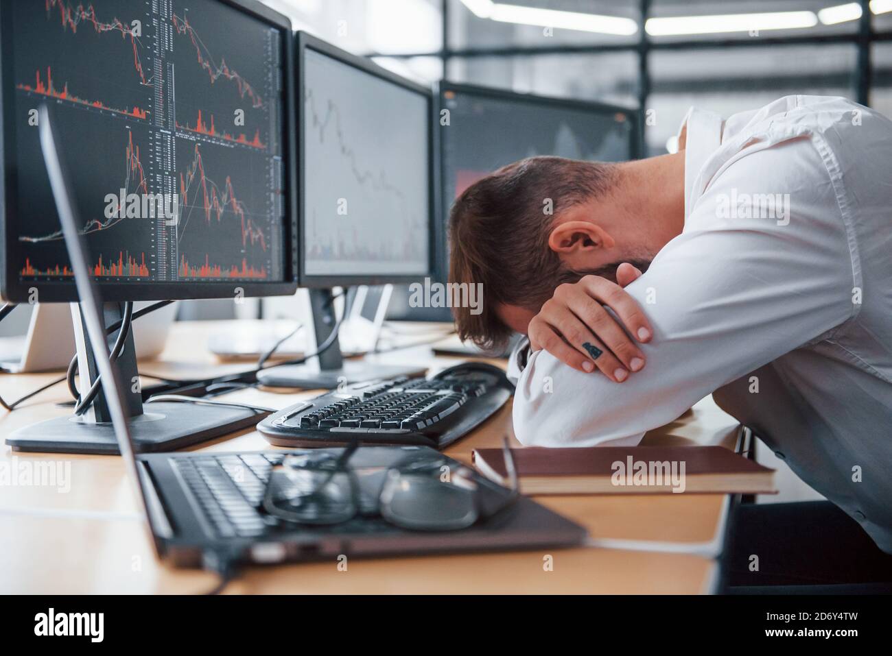 Tired businessman sleeping on the workplace by leaning on the table ...