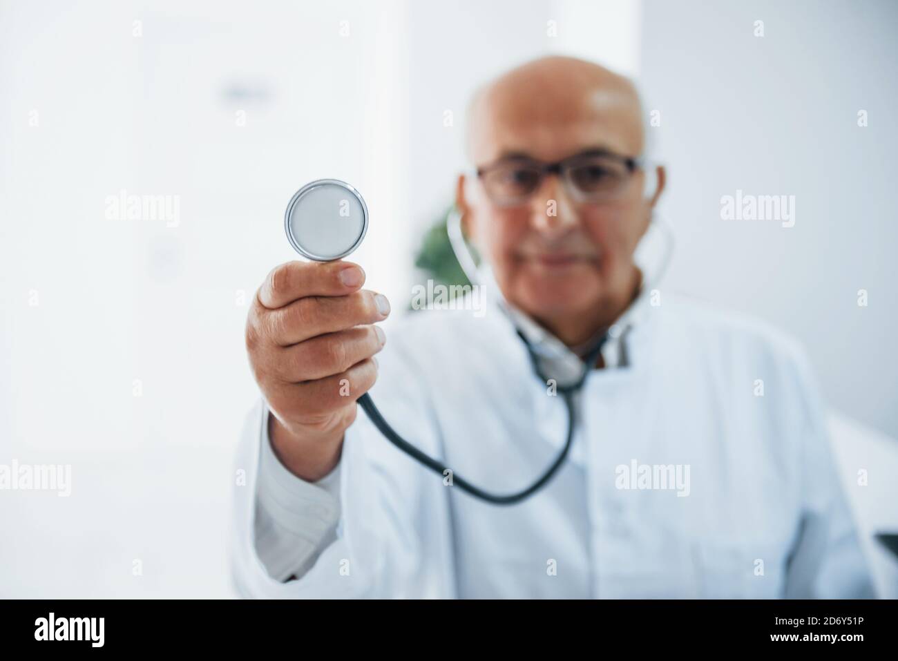 Portrait of senior doctor with stethoscope and in white uniform that ...