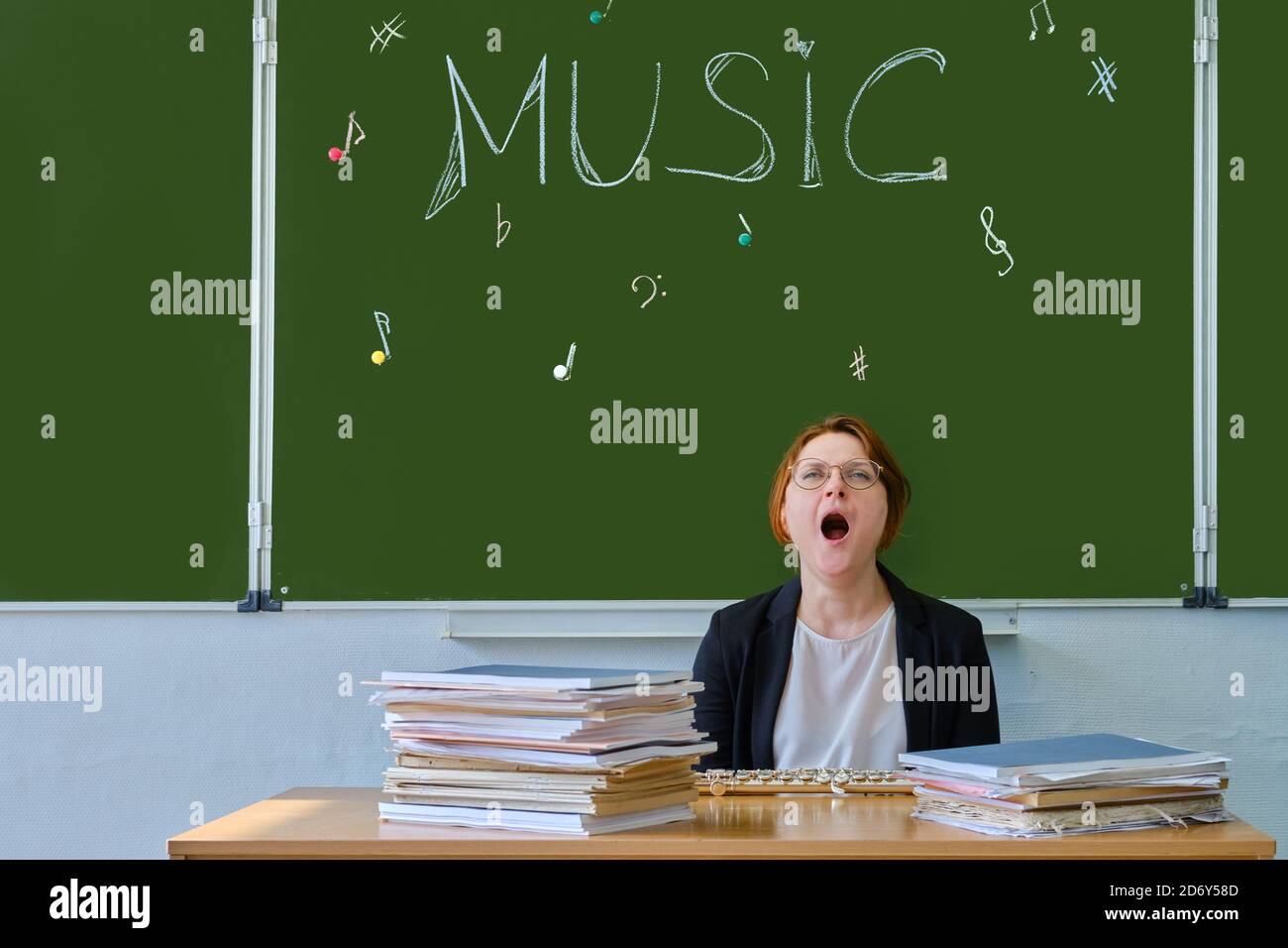 The school music teacher yawns during the lesson. Boring learning to ...