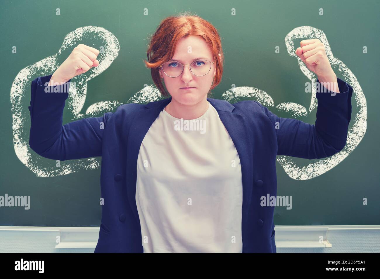 Strong school teacher with chalk drawn hands on a blackboard. Woman ...