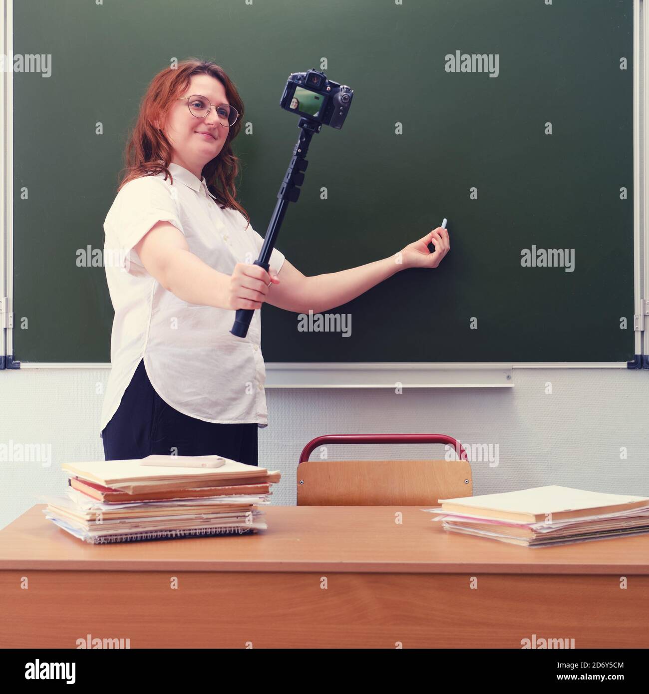 Online lesson and teacher with a camera at the blackboard. Education ...