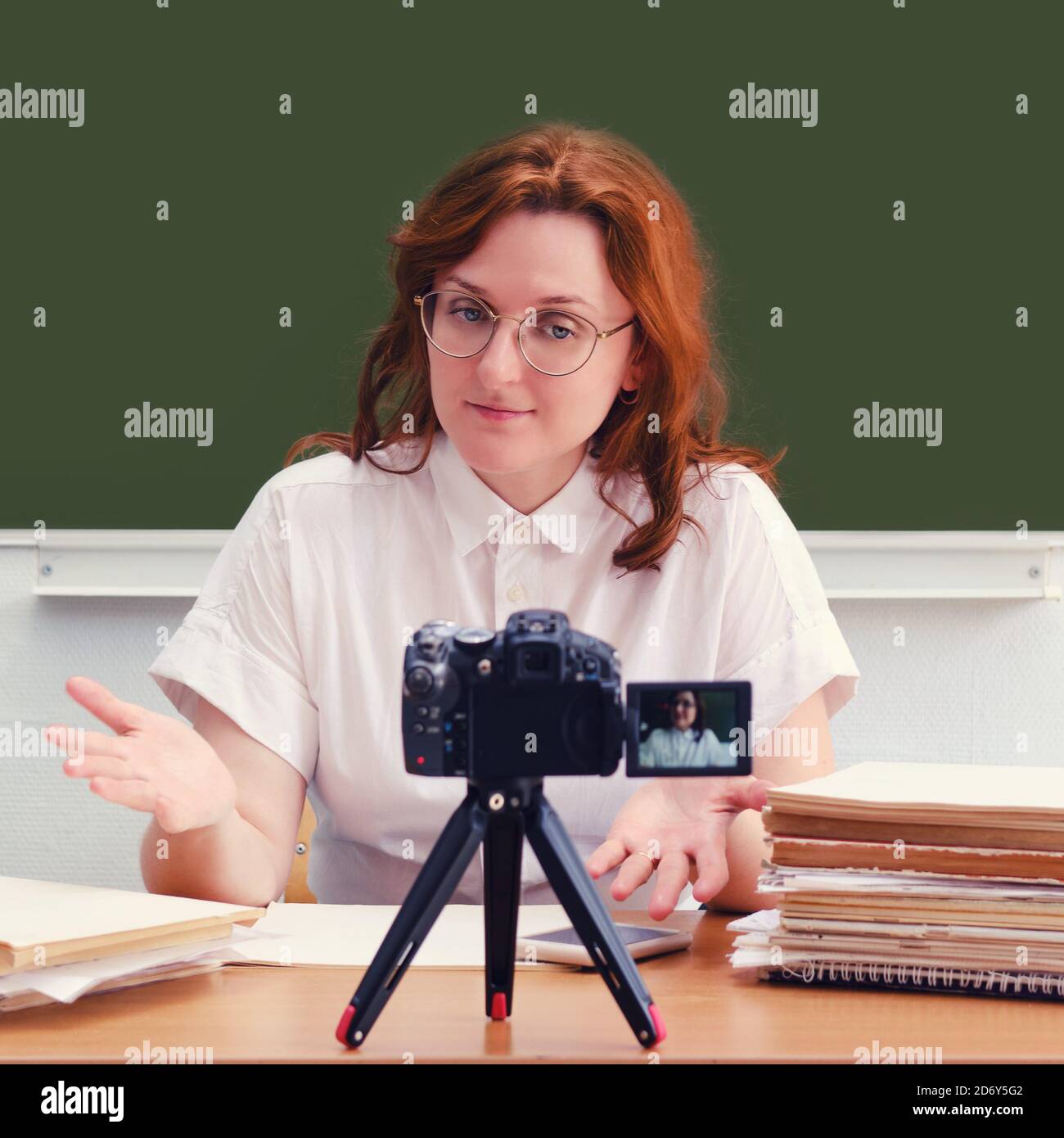 A female teacher conducts an online lesson in a school classroom ...