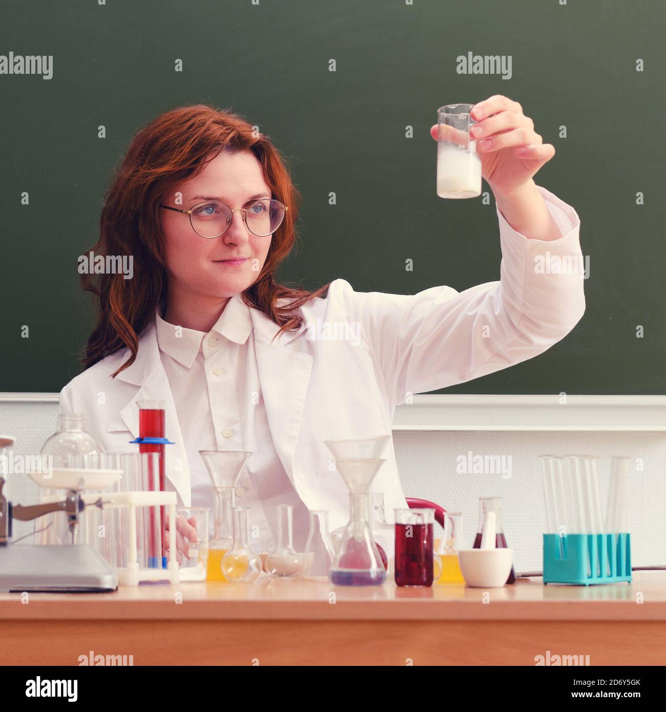A scientist looks at the reaction of a white turbid chemical liquid ...