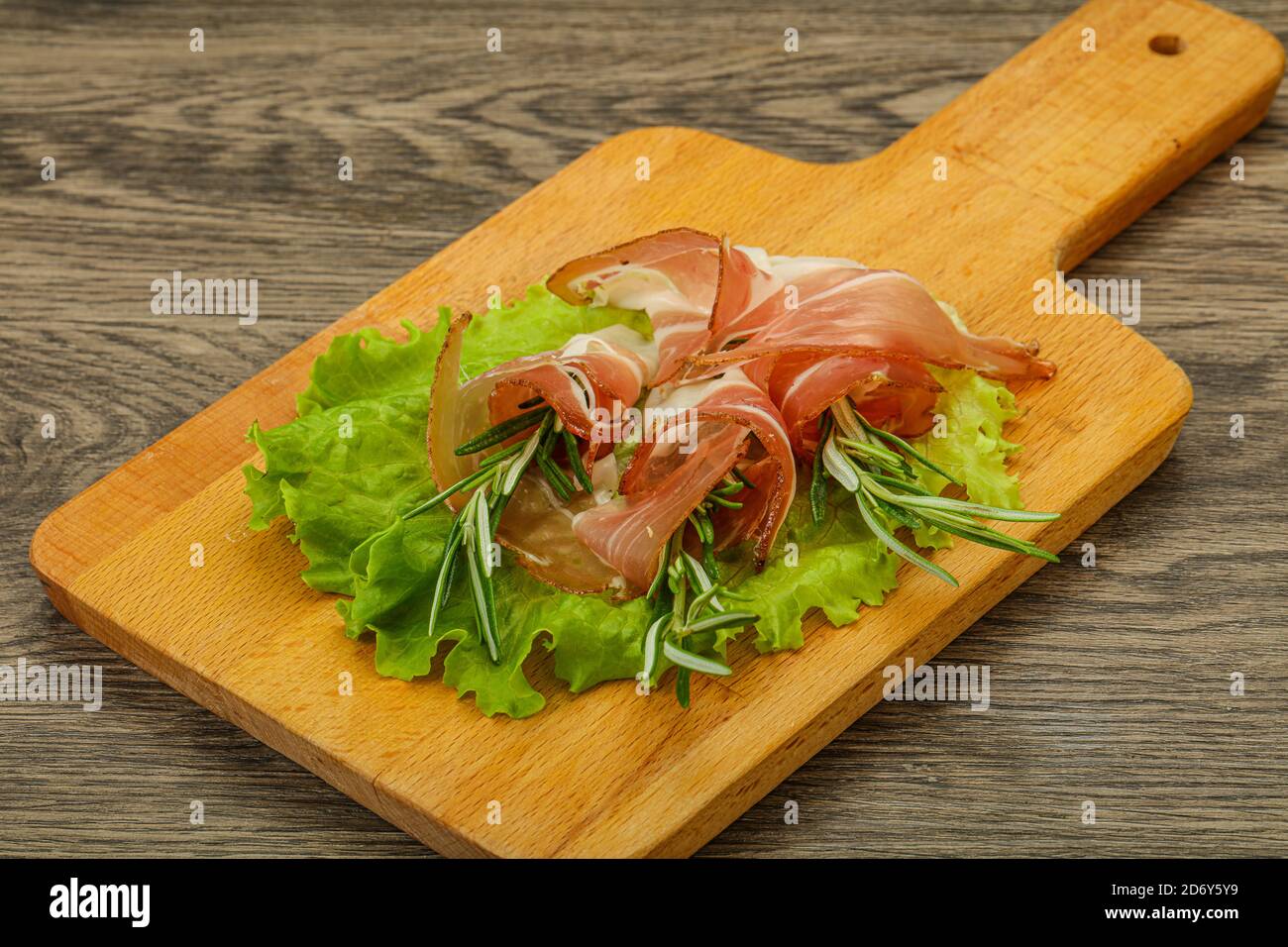 Sliced pork Jamon meat with rosemary Stock Photo - Alamy