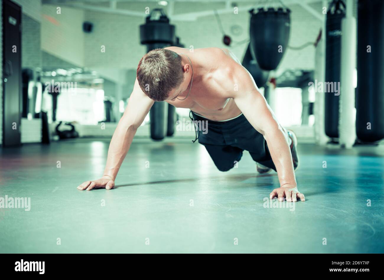 young sportive man making push-ups from sport equipment Stock Photo - Alamy