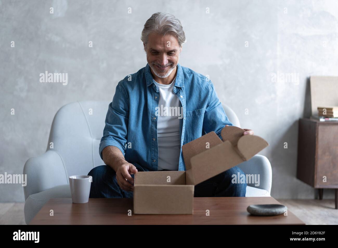 Smiling man consumer open cardboard box get postal parcel, male ...