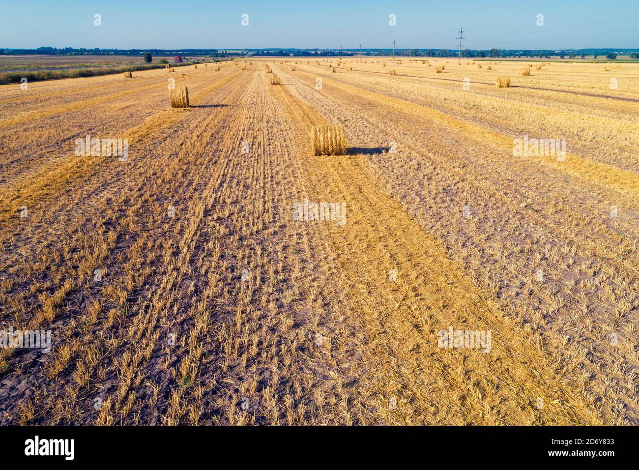 Aerial top view of the colorful geometric wheat fields with straw bales ...