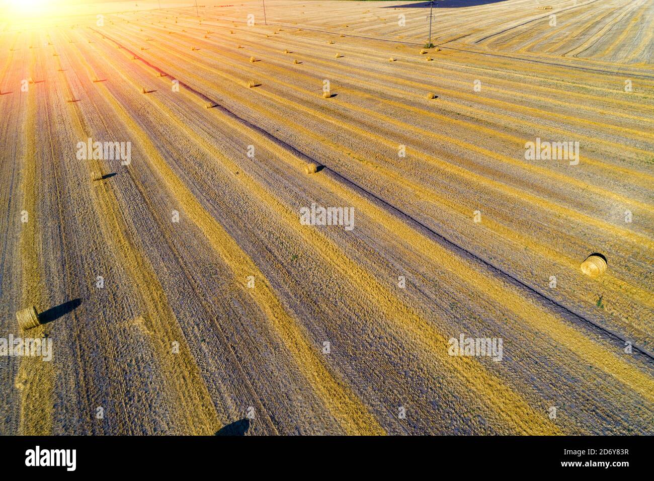 Aerial top view of the colorful geometric wheat fields with straw bales ...