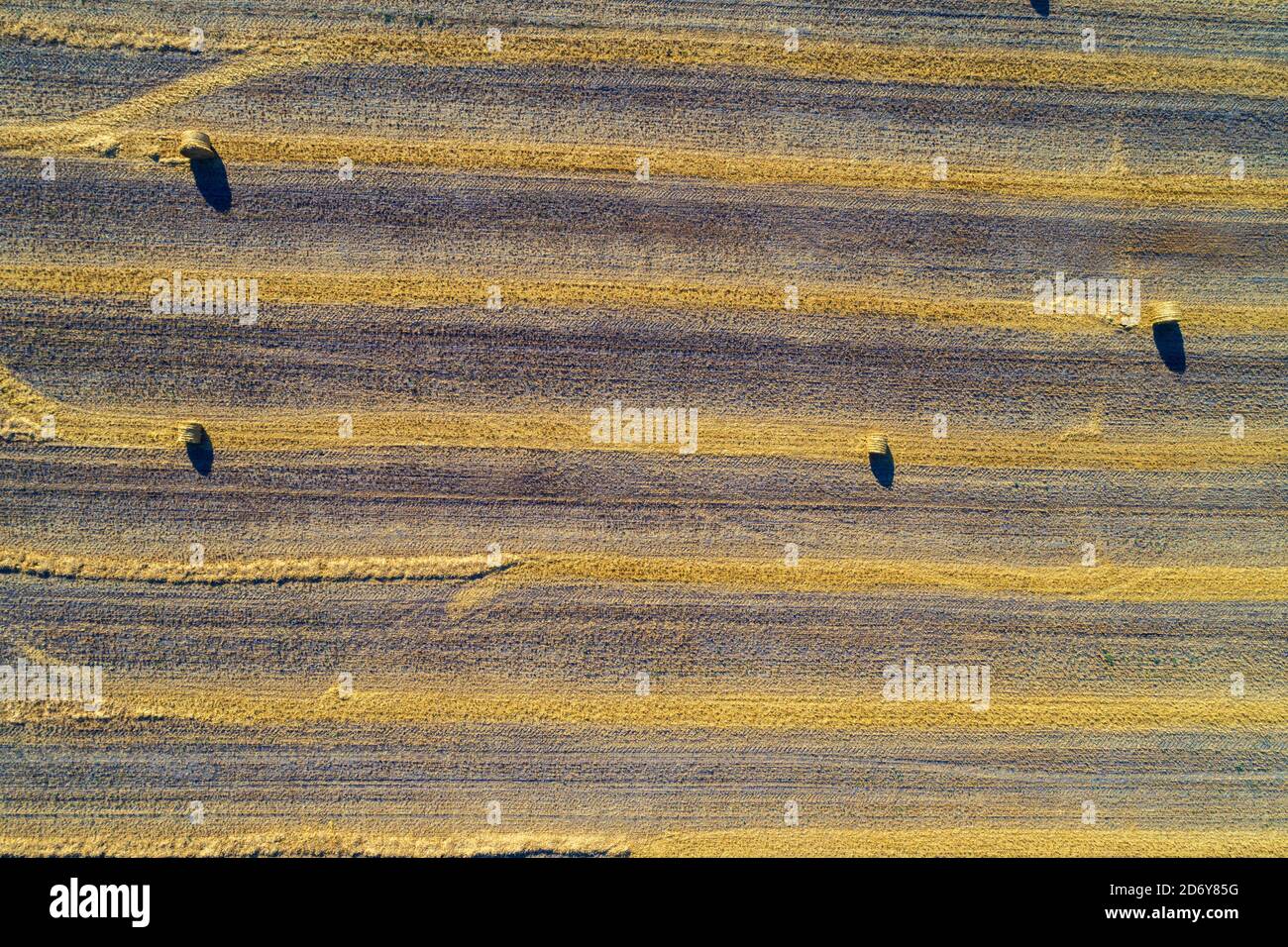 Aerial top view of the colorful geometric wheat fields with straw bales ...