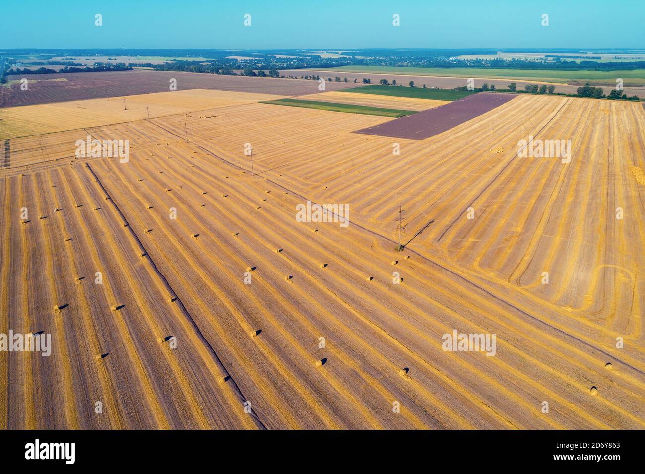 Aerial top view of the colorful geometric wheat fields with straw bales ...
