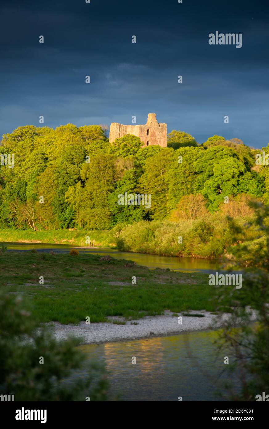 Norham Castle sitting high above the River Tweed on a summers evening ...