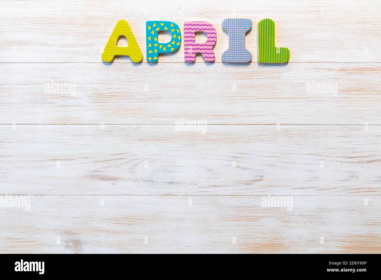 Wooden letters written April month on vintage background. Inscription ...