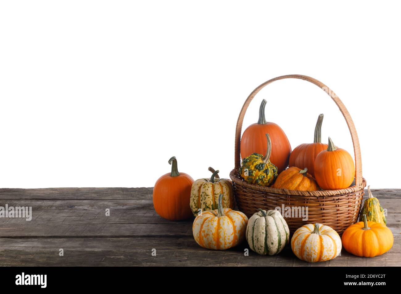 Little pumpkins in basket still life on table isolated on white ...