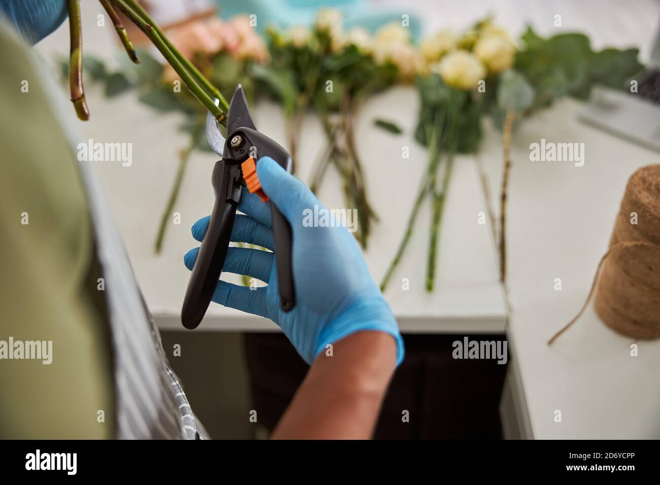 Florist using scissors while making bouquet at work Stock Photo - Alamy