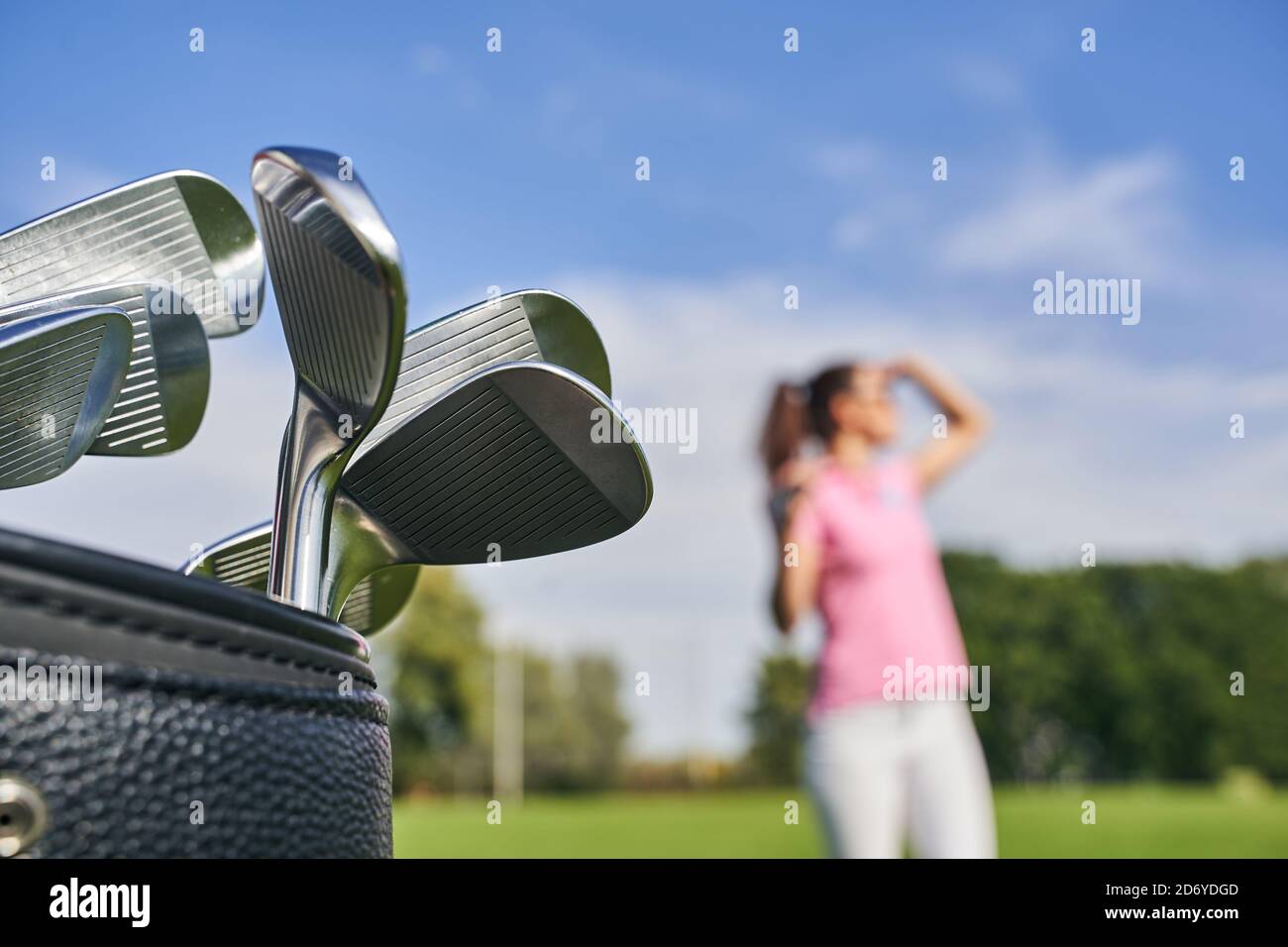Dark-haired lady golfer on the driving range Stock Photo - Alamy
