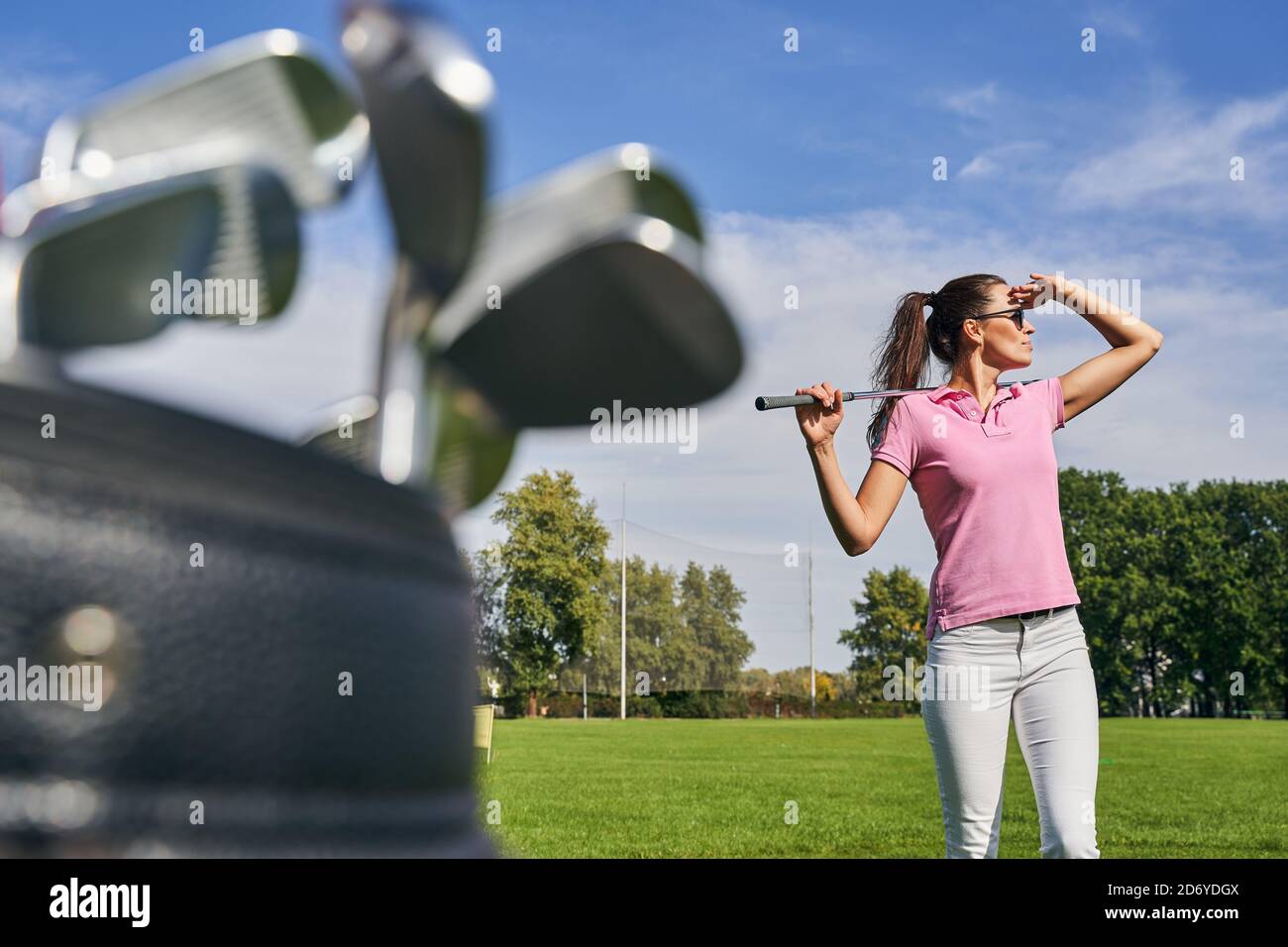 Woman with a golf club over her shoulder Stock Photo - Alamy