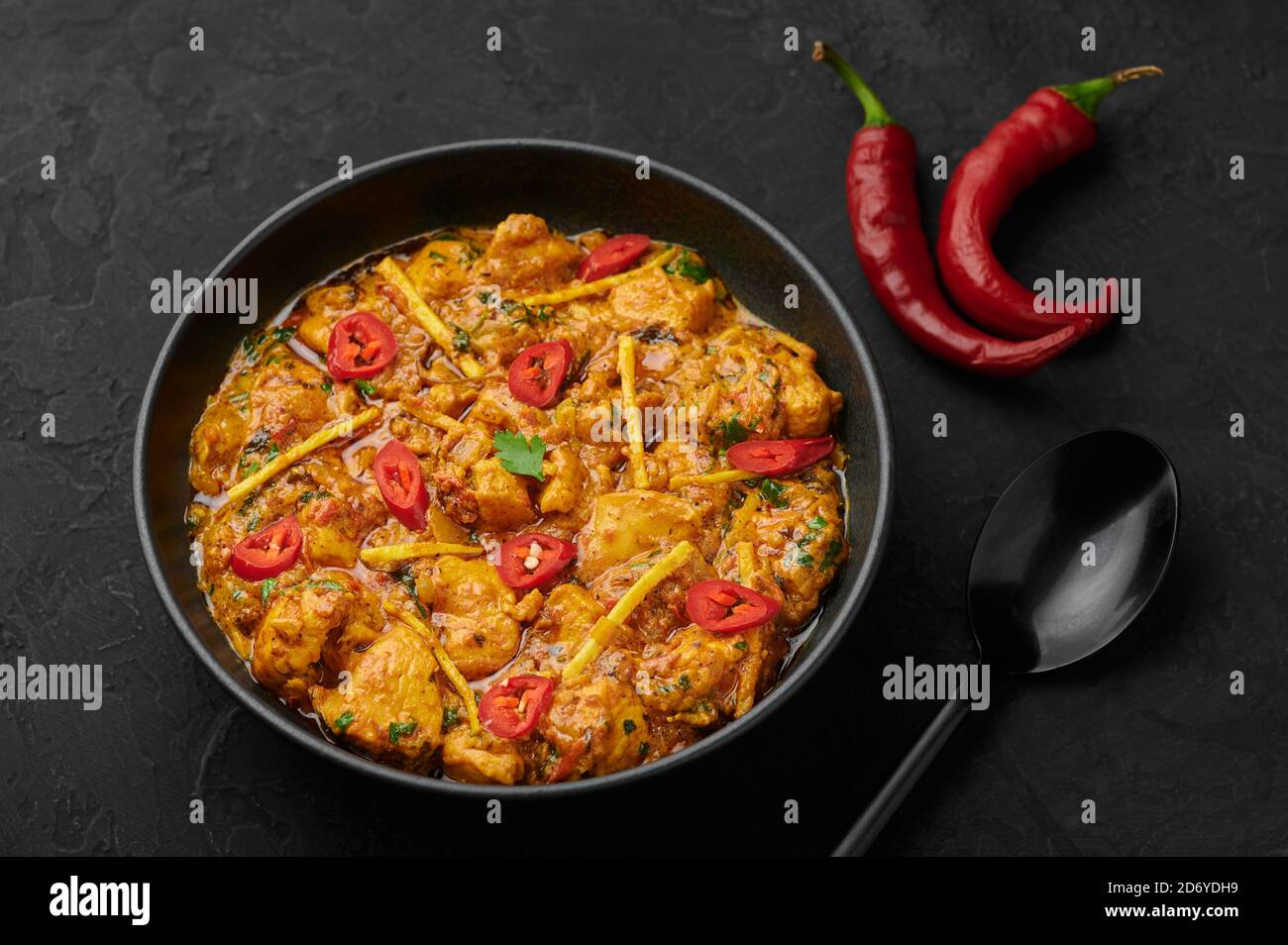 Chicken Handi in black bowl on dark slate table top. Murgh Chicken is ...