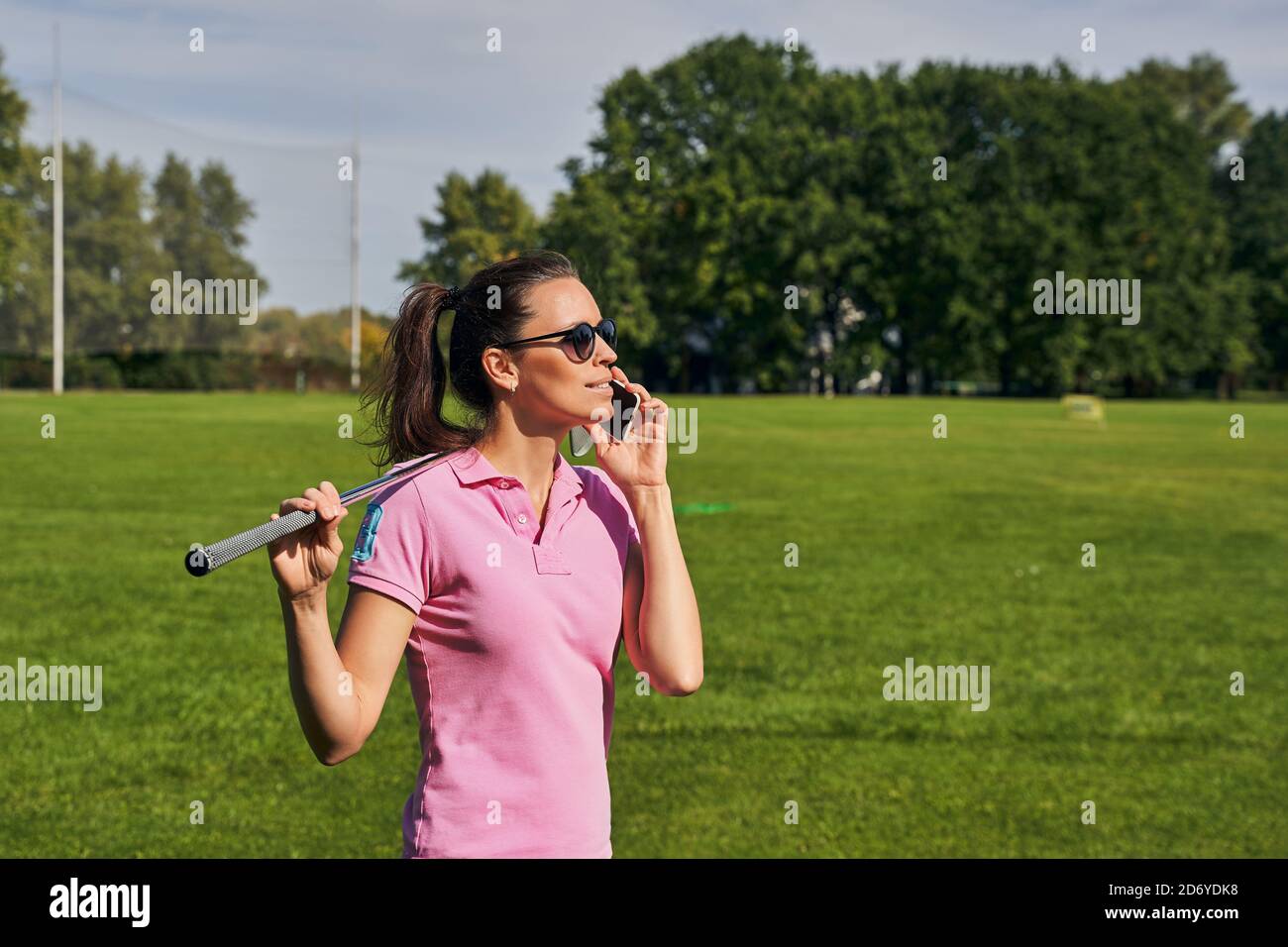Attractive golf player using her gadget outside Stock Photo - Alamy