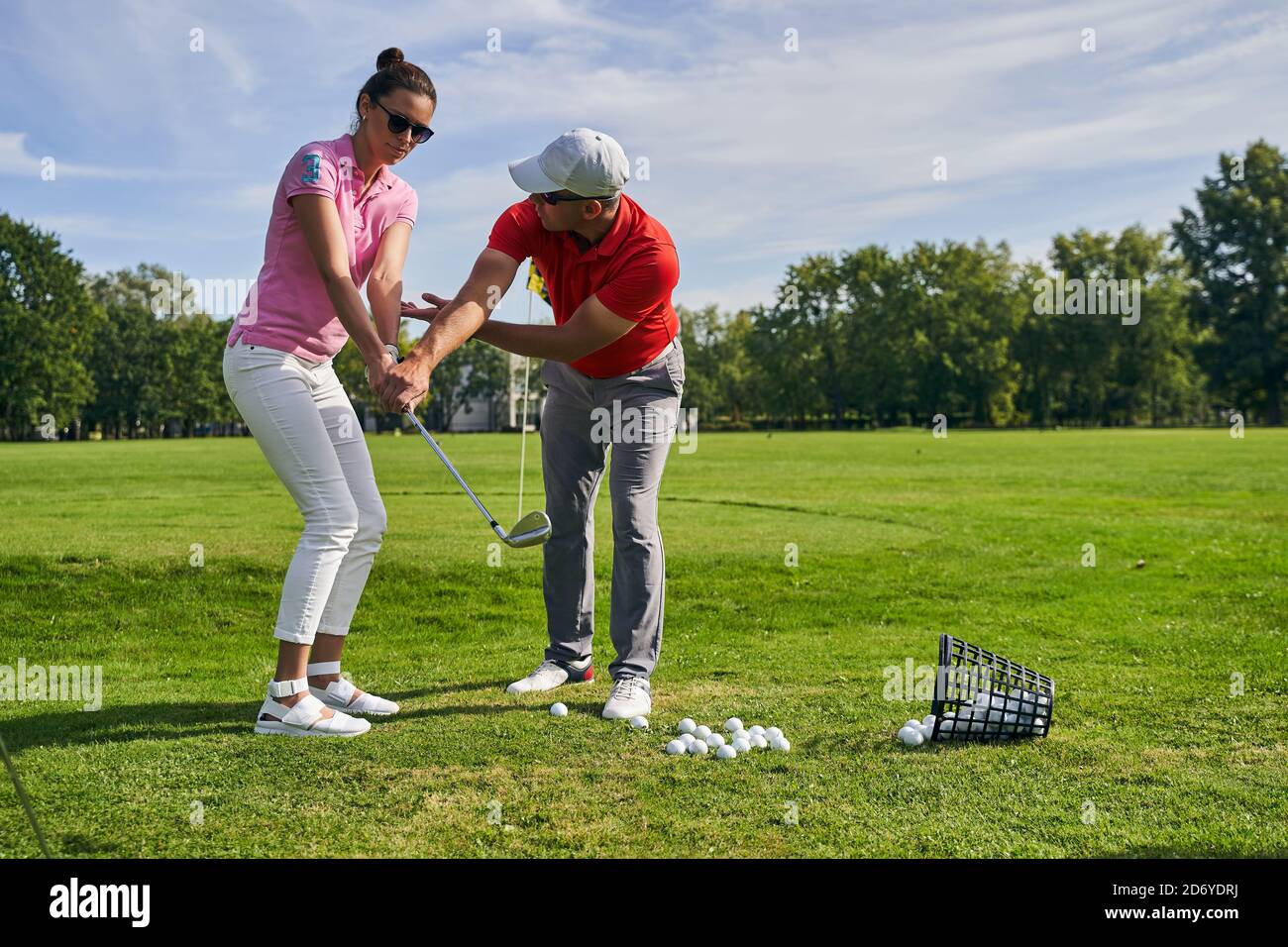 Instructor teaching his client a golf technique Stock Photo - Alamy