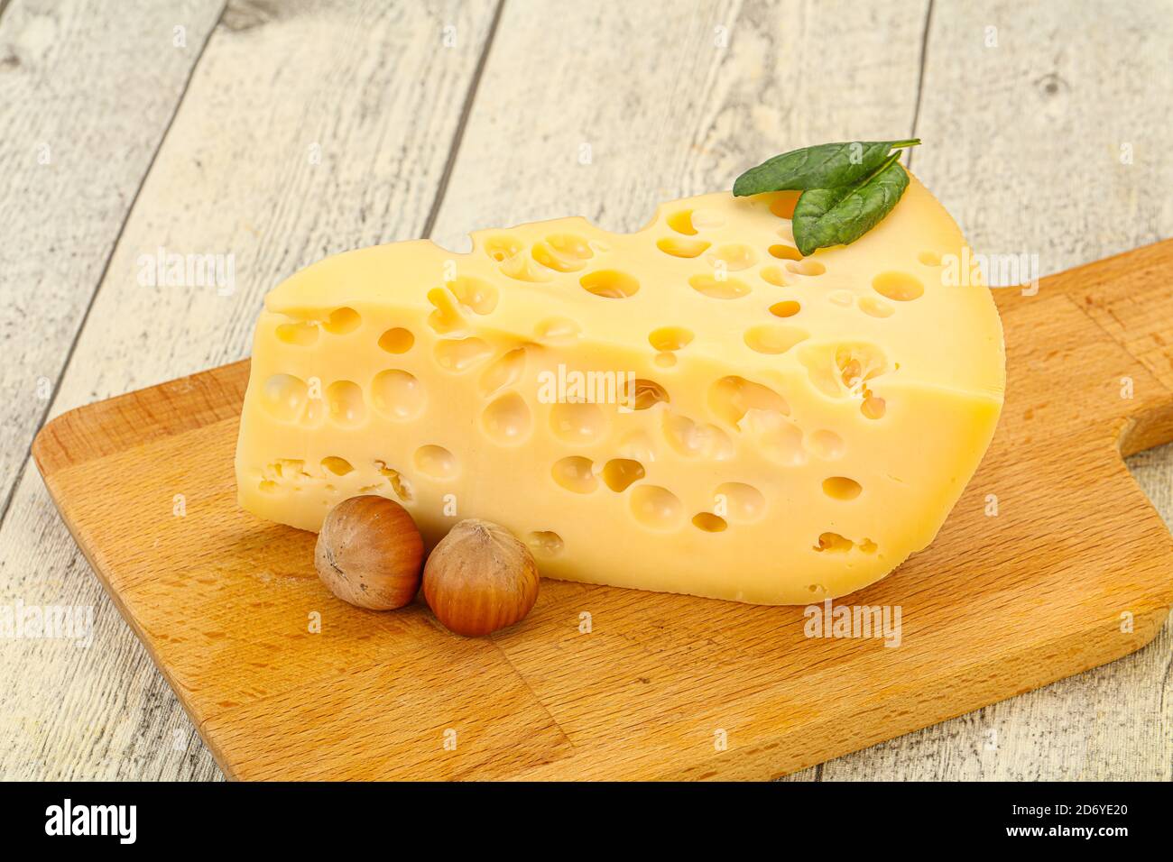 Maasdam cheese - dairy yellow triangle with holes Stock Photo - Alamy