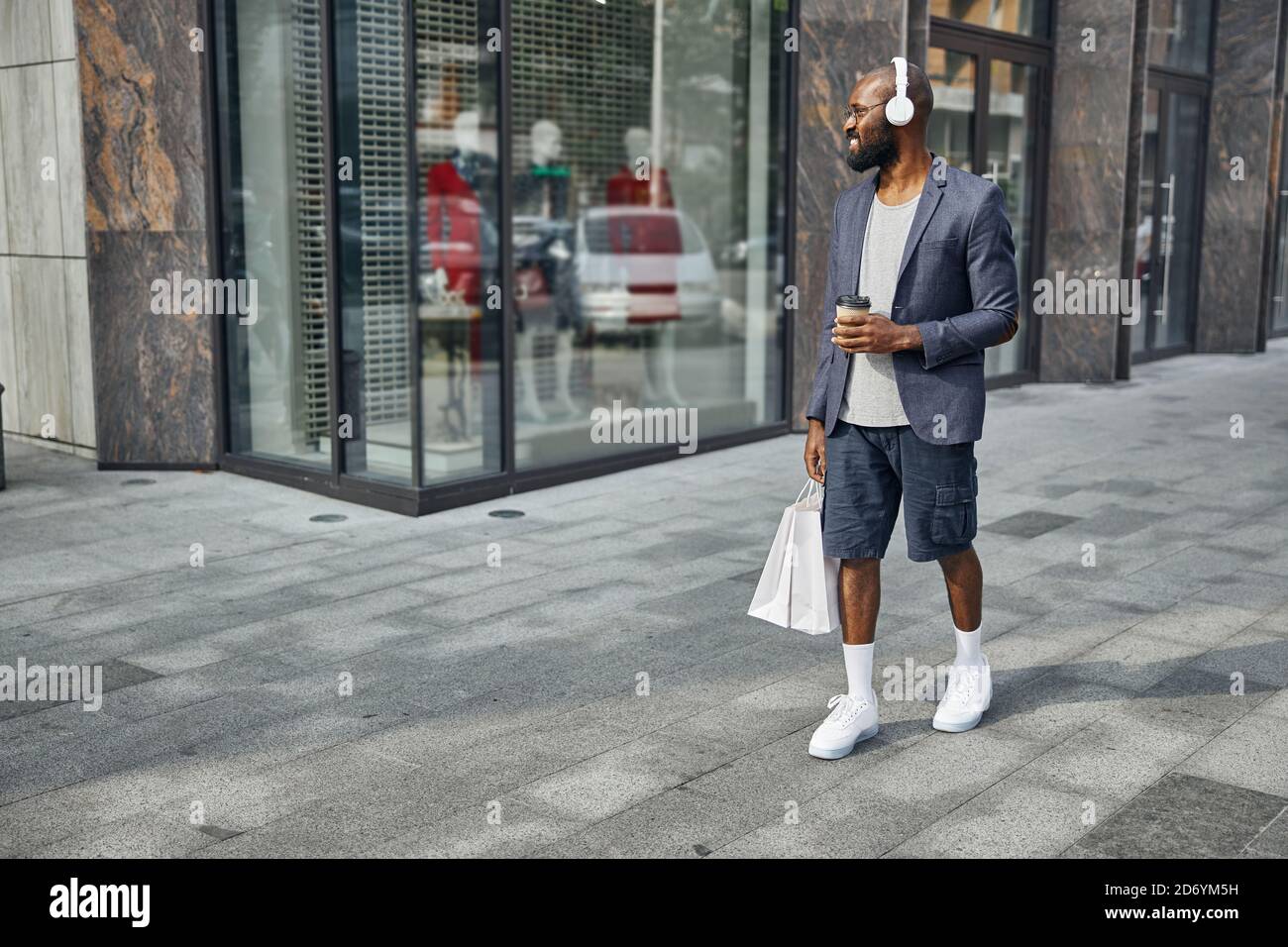 Cheerful international man looking at glass case Stock Photo - Alamy