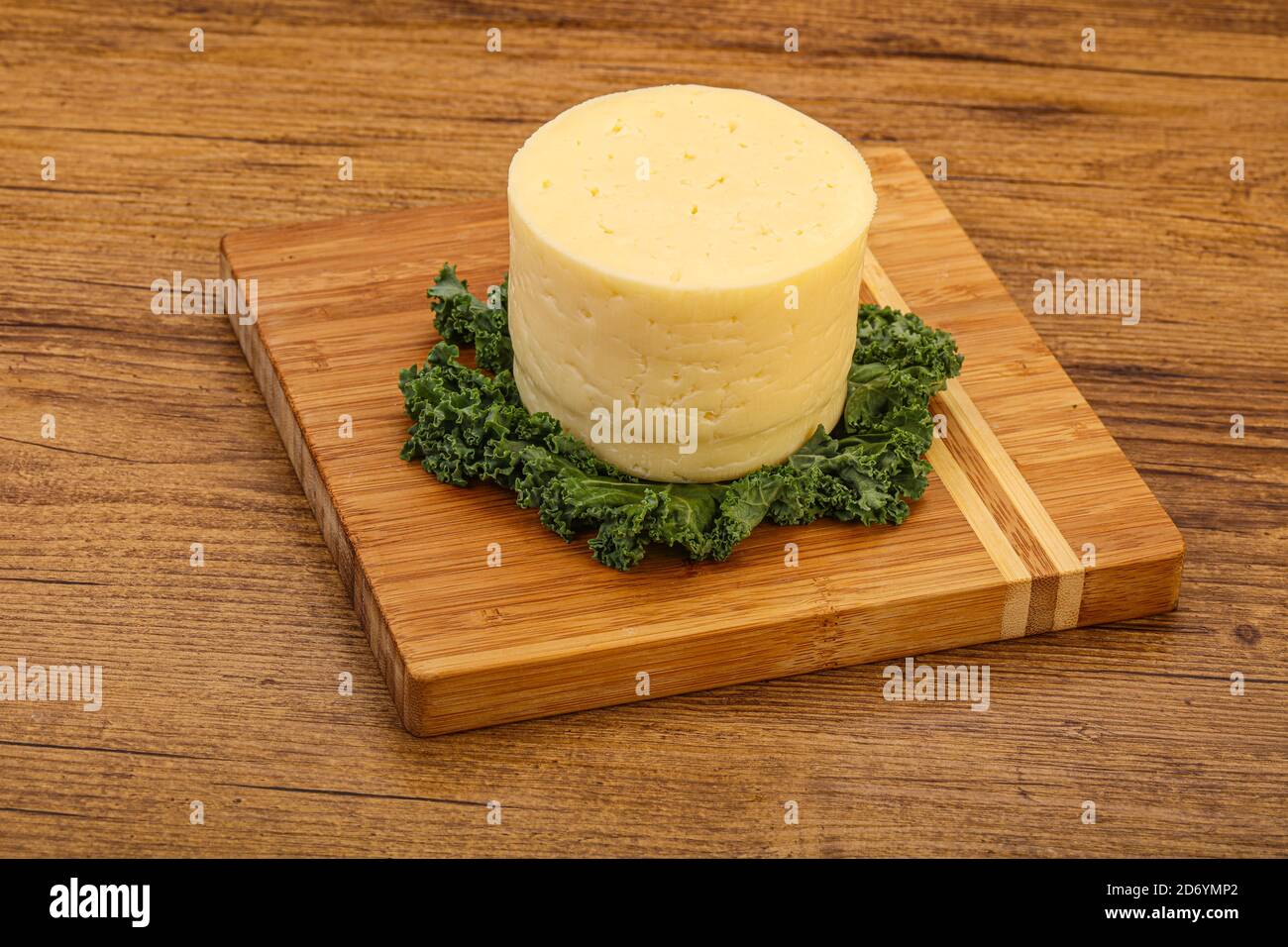 Yellow round dairy soft cheese piece Stock Photo - Alamy