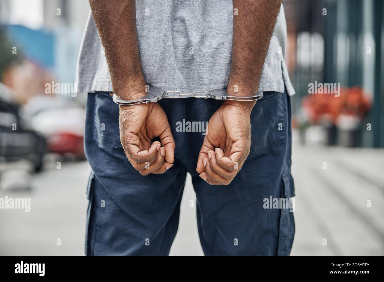 Back view of young foreigner being handcuffed Stock Photo - Alamy