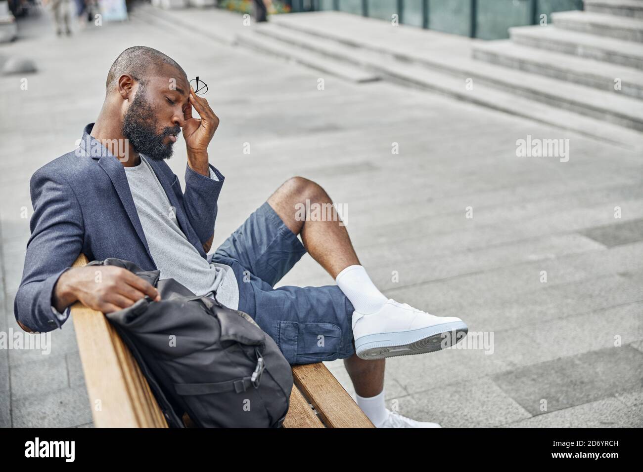 Tired male person sitting on the bench Stock Photo - Alamy