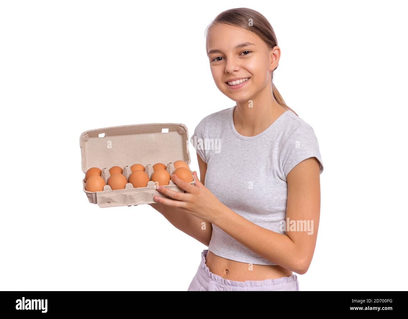 Happy cute teen girl holding brown eggs in box, isolated on white ...