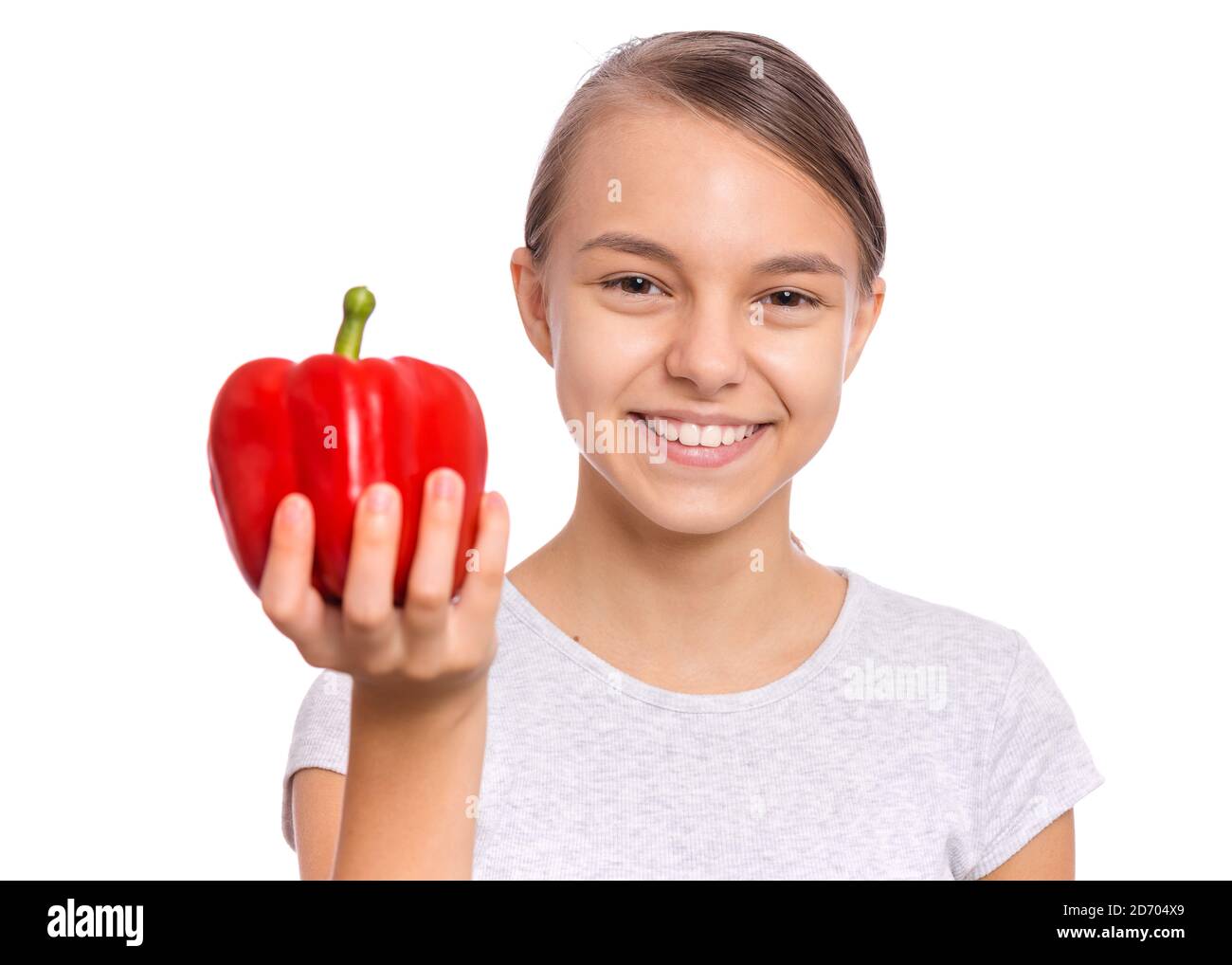 Beautiful young teen girl holding bell pepper, isolated on white ...