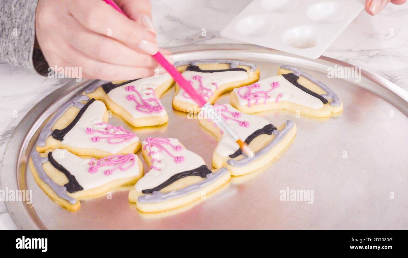 Brushing edible glitter on iced figure skate sugar cookies Stock Photo ...