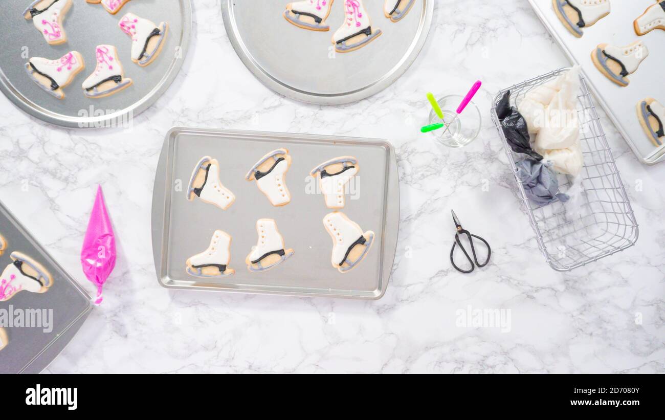 Flat lay. Icing figure skate shaped sugar cookies with royal icing ...