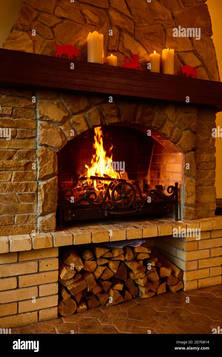 Warm cozy fireplace with real wood burning in it. Cozy winter concept ...