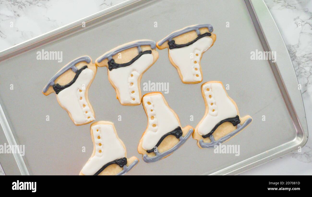 Flat lay. Icing figure skate shaped sugar cookies with royal icing ...