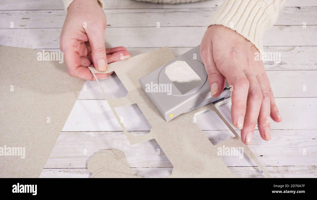 Step by step. Cutting out gift tags from brown paper with a paper punch ...